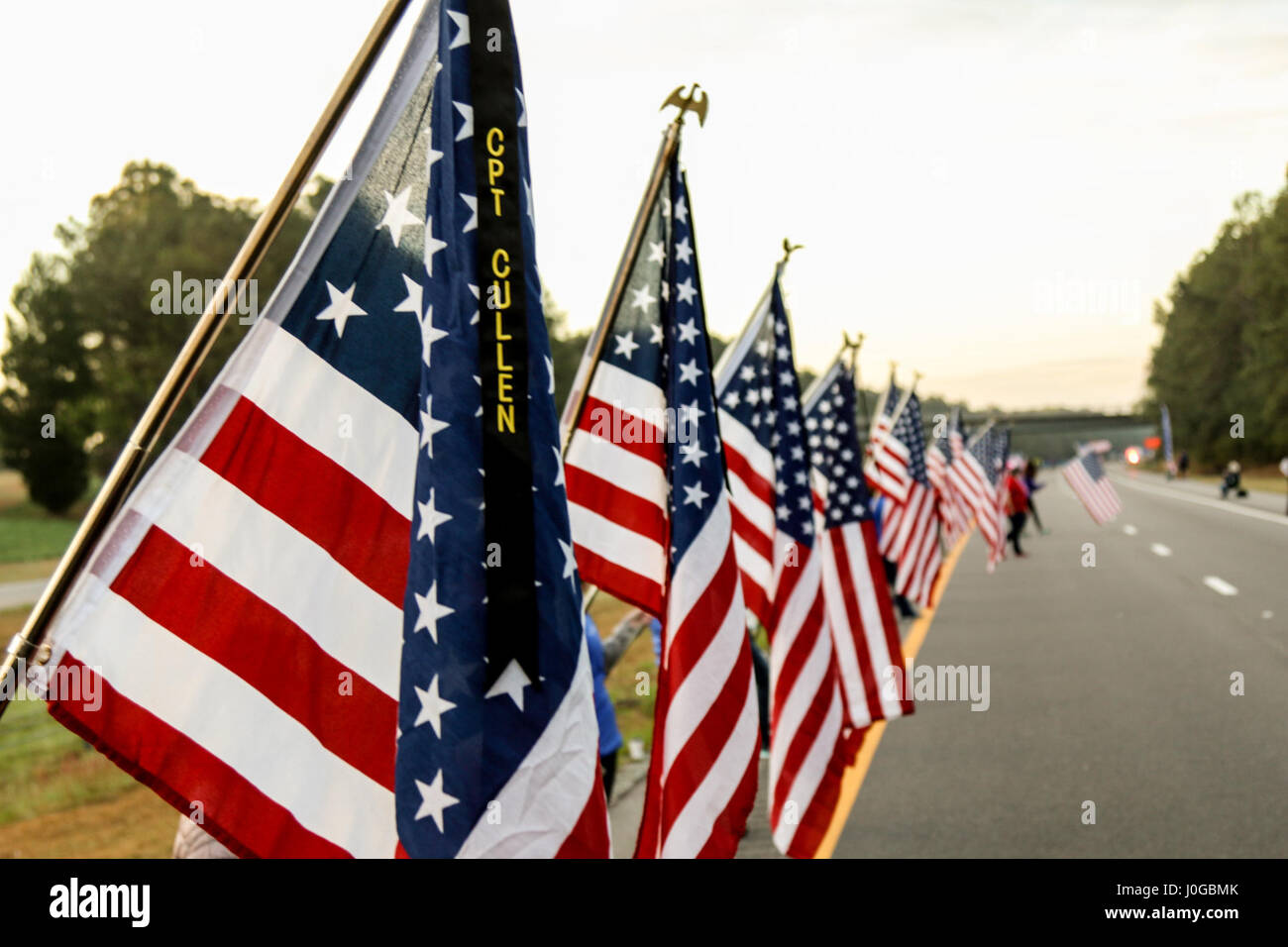 A row of flags bearing the names of fallen service members line edge of ...