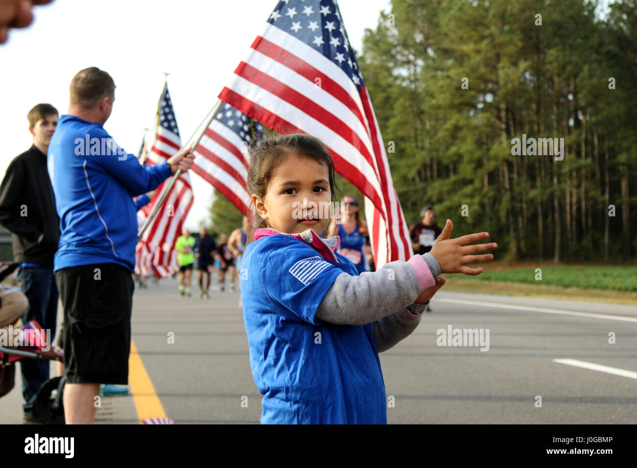 A child with wear blue: run to remember, waits on the side of the All ...