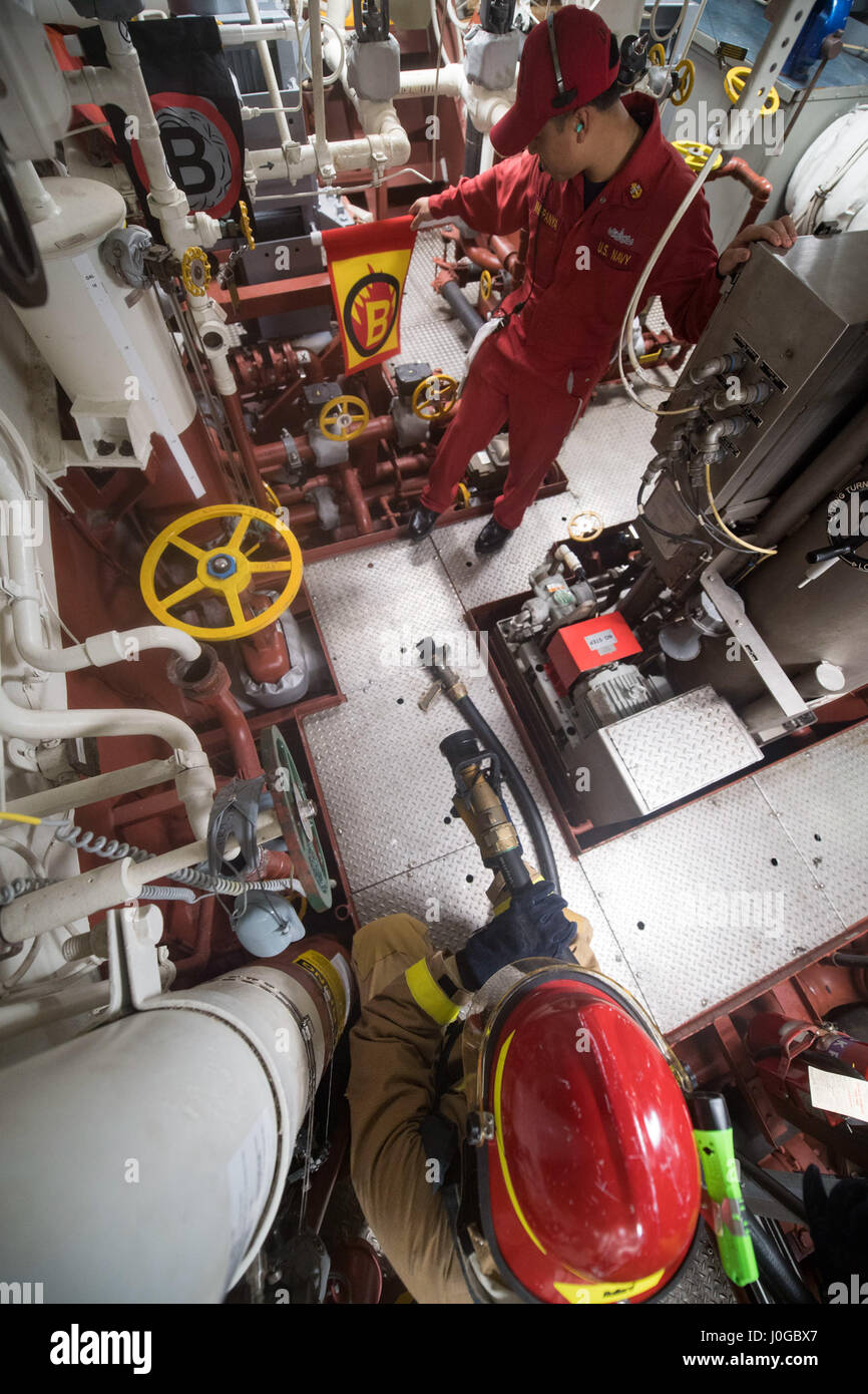 Chief Damage Controlman simulates a fire during a damage control drill ...