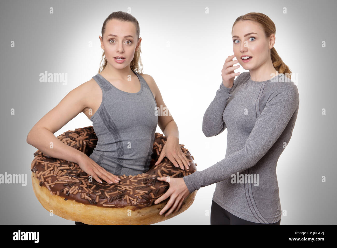 concept idea of two woman one with a large donut around her waist ...