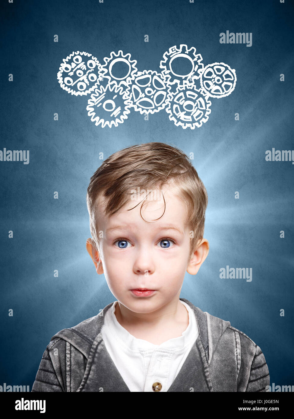 Smart child thinks of looking at gears Stock Photo - Alamy