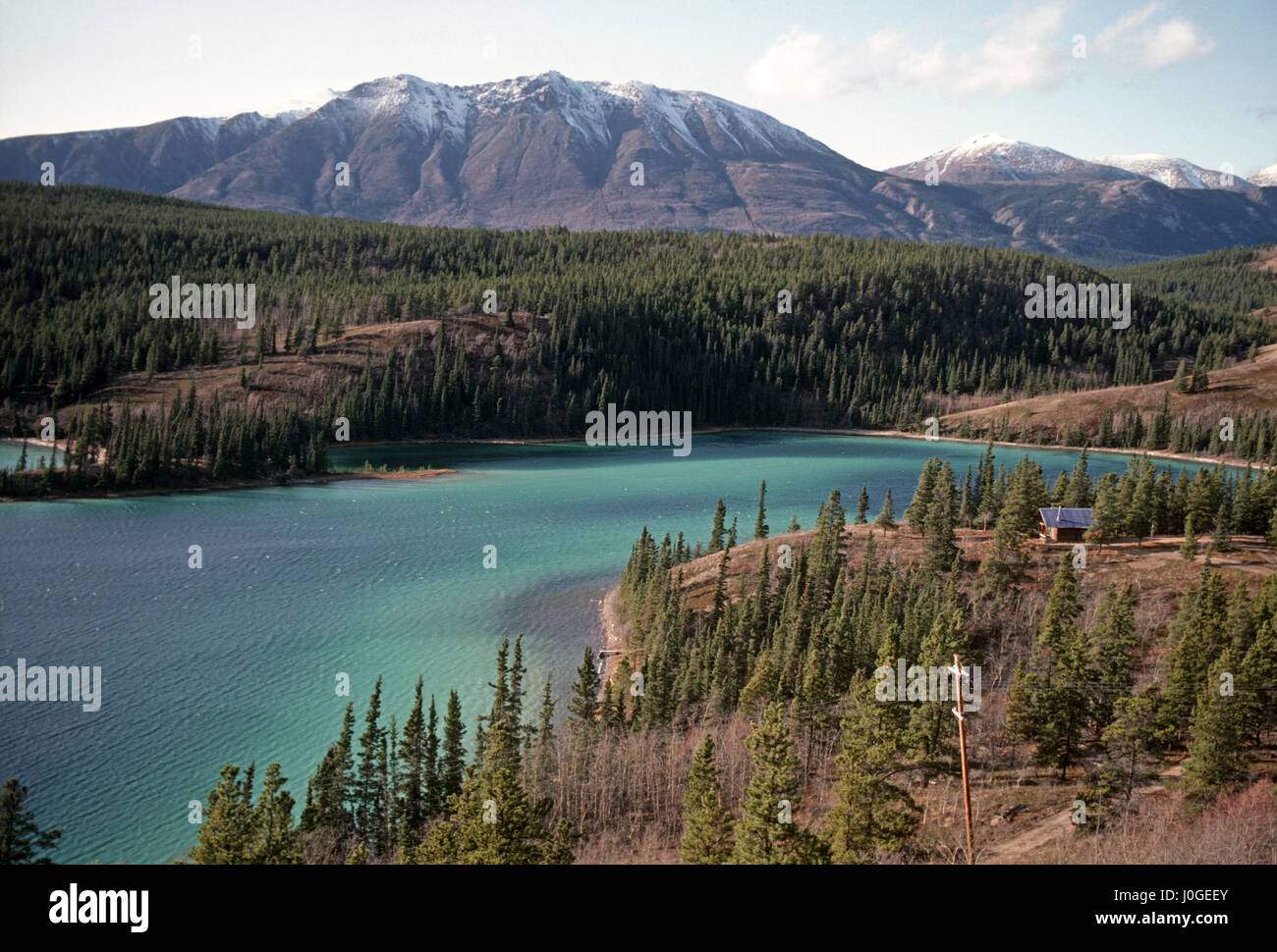 Log cabin on edge of Emerald Lake near Carcross, Yukon Territories ...