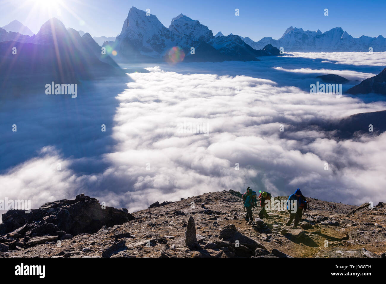 In the Nepal Himalaya, trekkers ascend Gokyo Ri with mountains in the ...