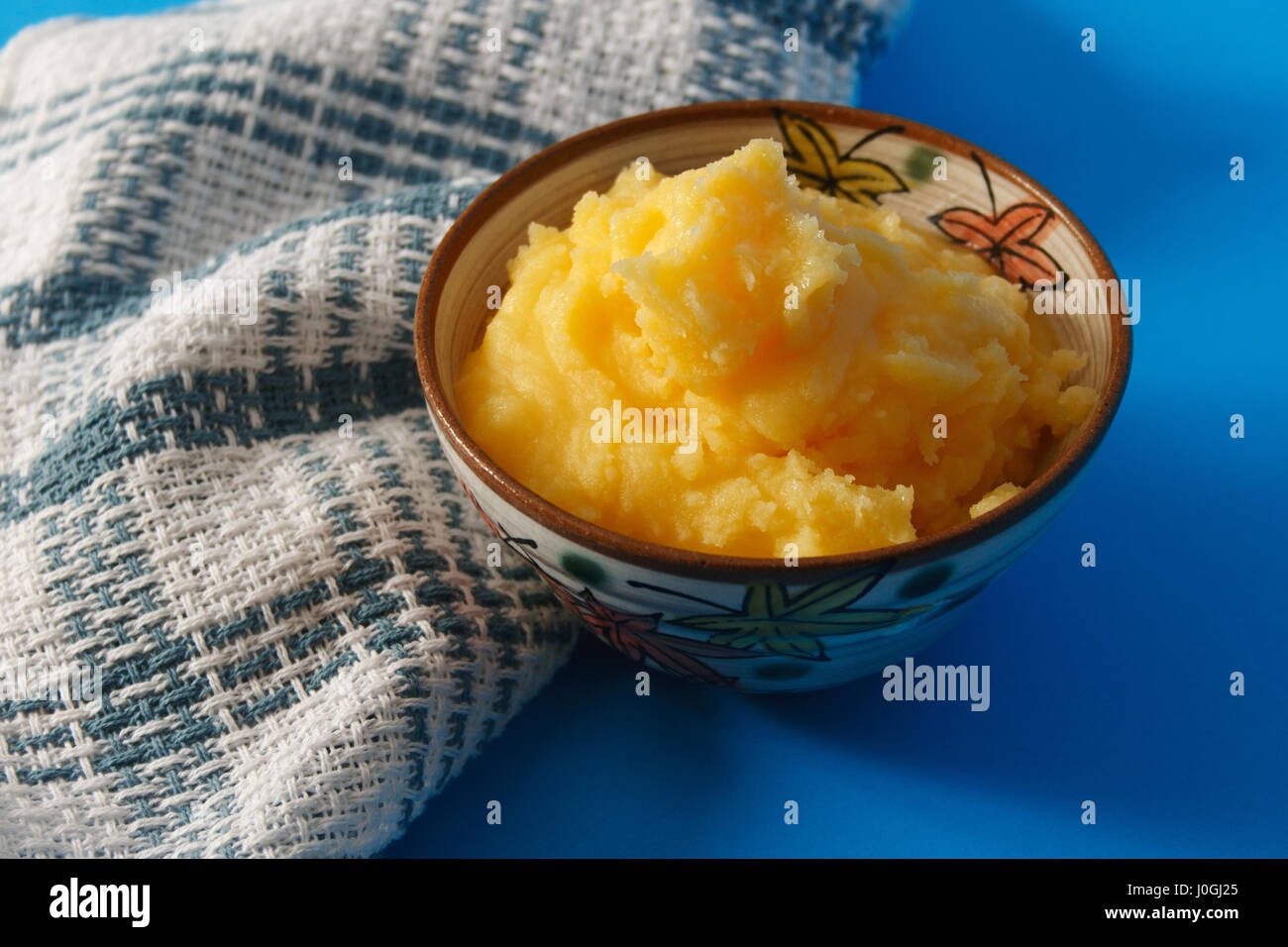 Ghee in ceramic bowl on a blue background Stock Photo - Alamy