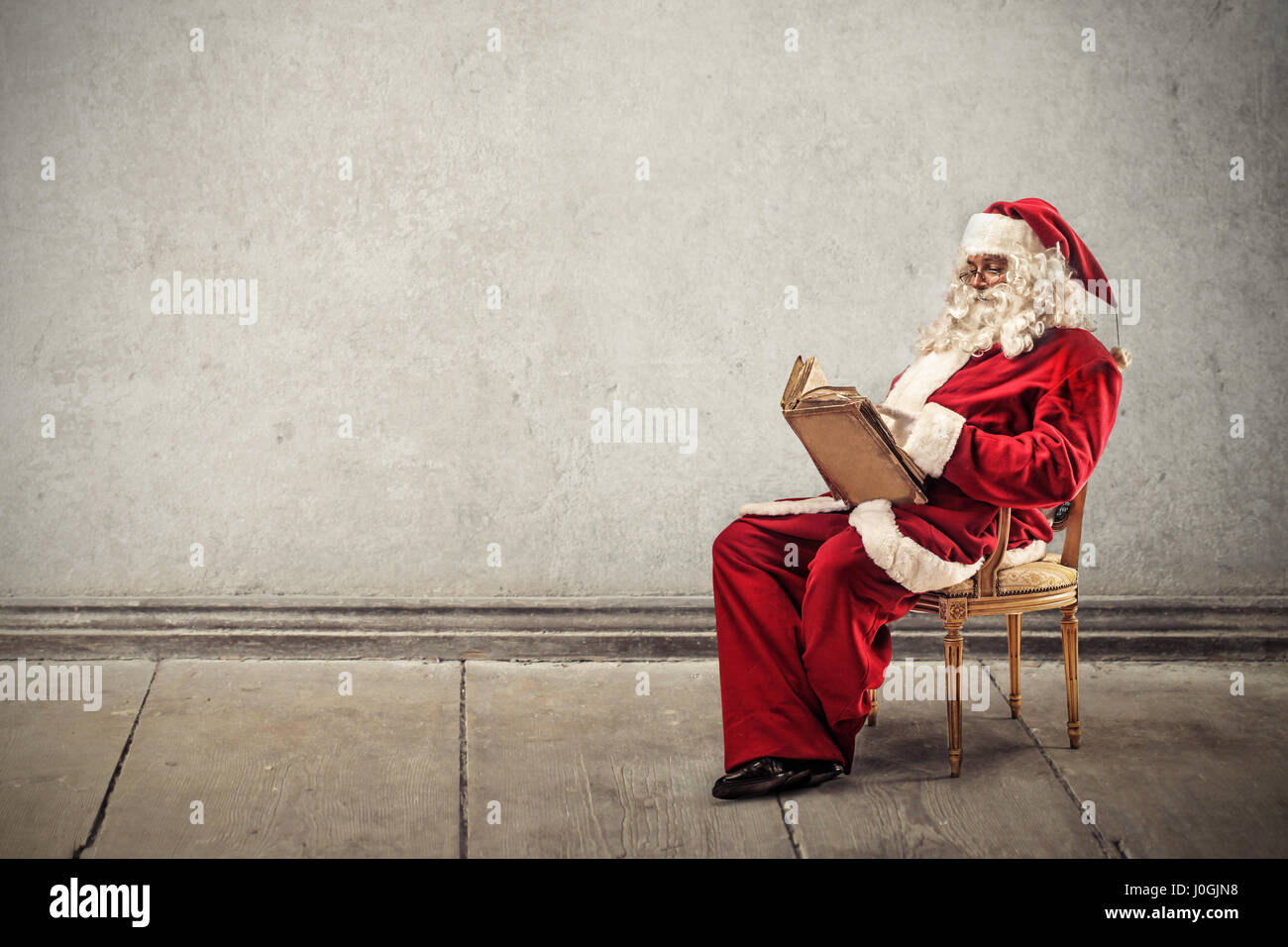 Santa Claus reading old book Stock Photo - Alamy