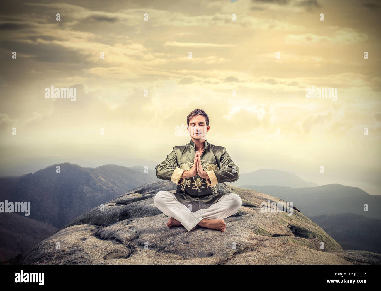 Man meditating on mountain Stock Photo - Alamy