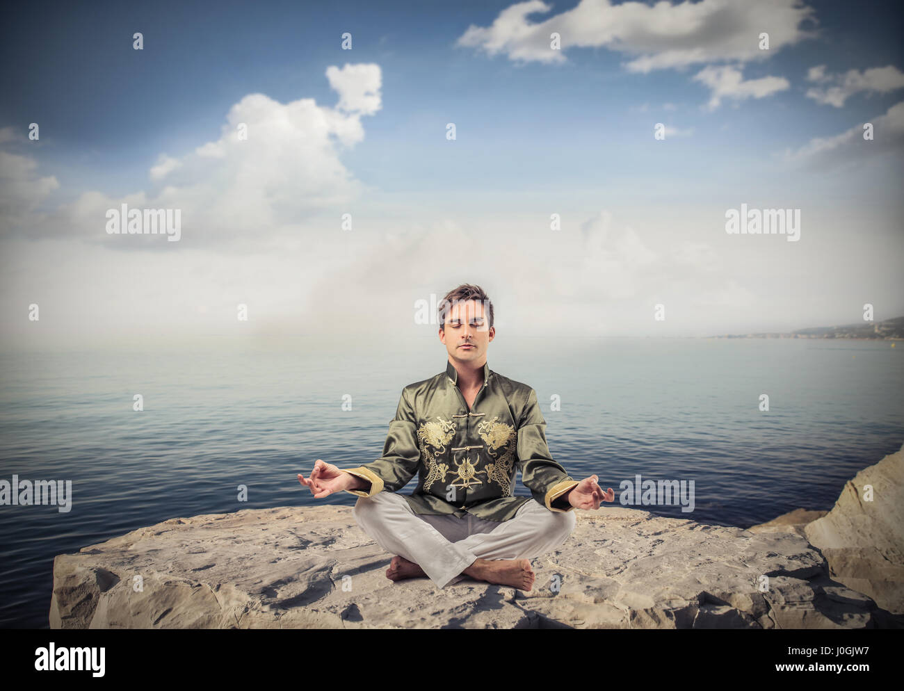 Man meditating on the beach Stock Photo - Alamy
