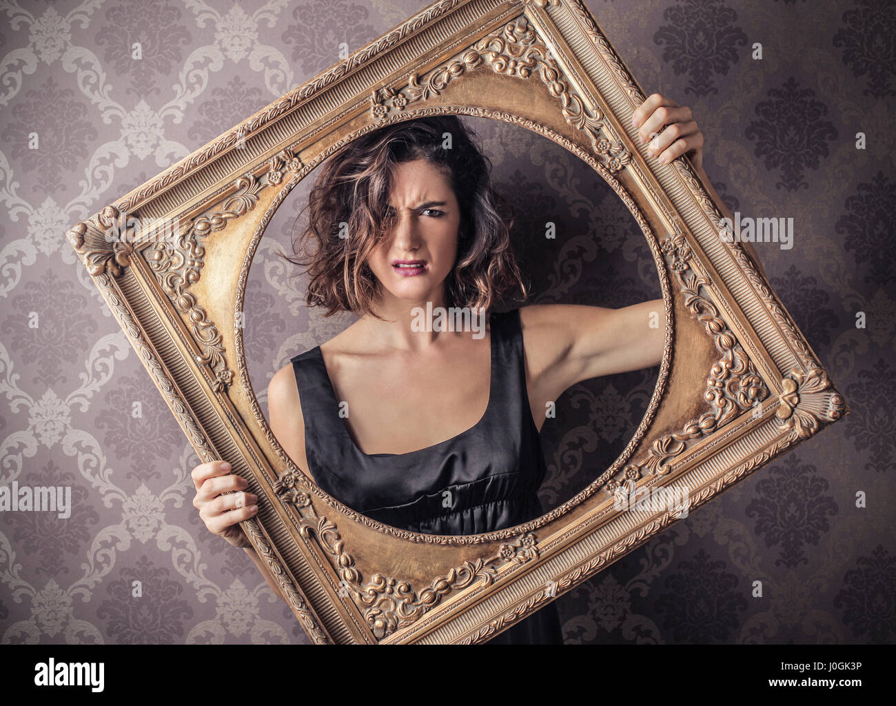 Brunette woman holding a frame Stock Photo - Alamy