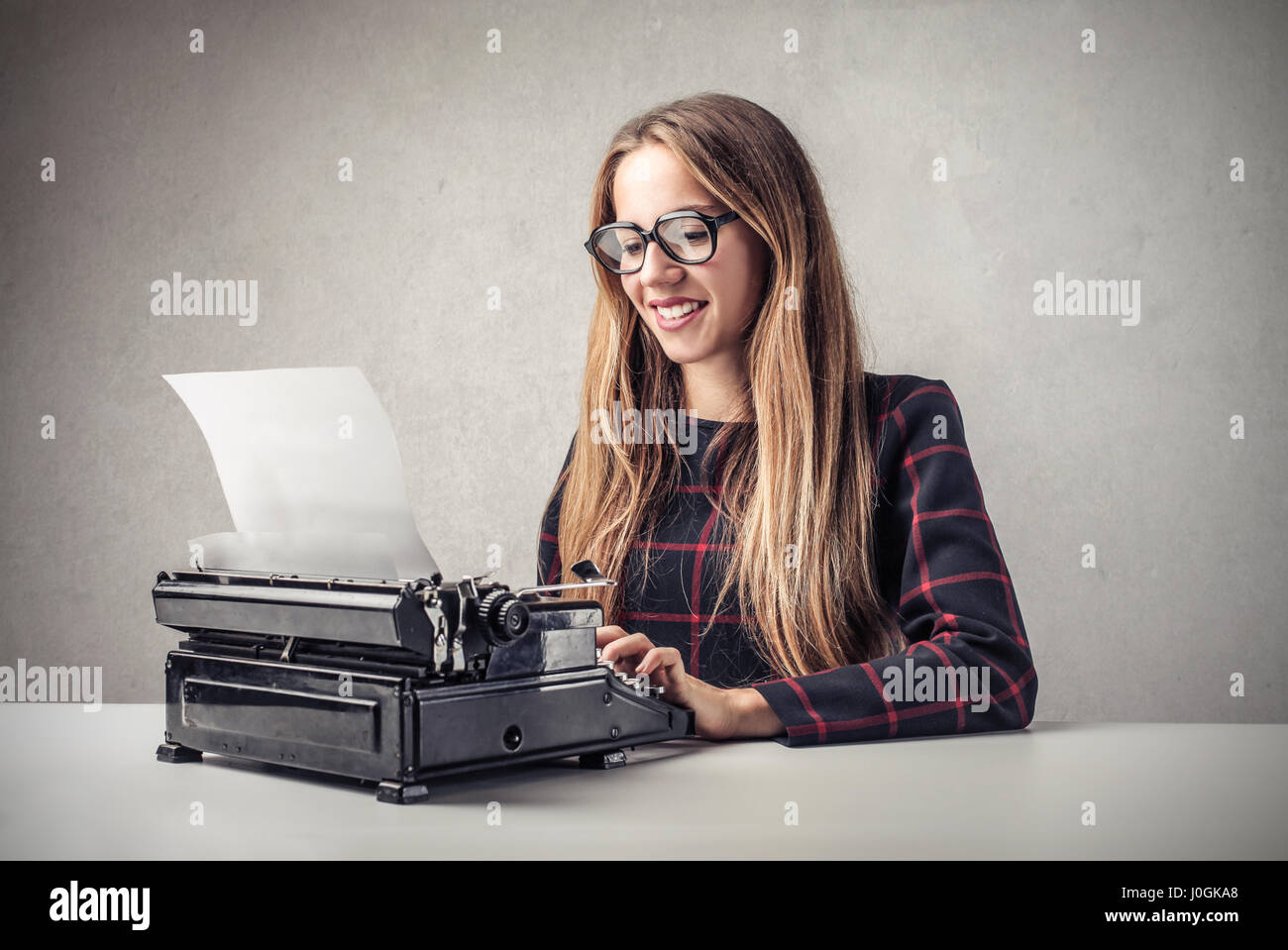 Blond woman using typewriter Stock Photo - Alamy