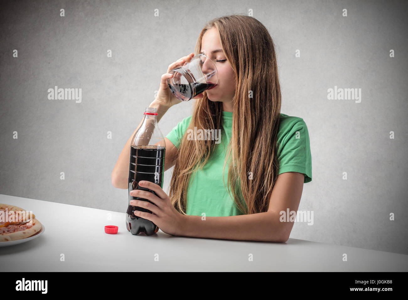 Blond woman drinking coke Stock Photo - Alamy