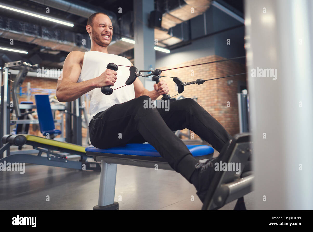 Male athlete working on rowing machine Stock Photo - Alamy