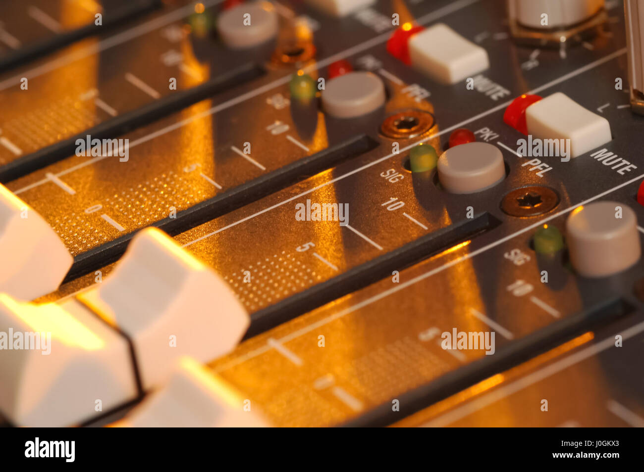 mixing soundboard illuminated by golden stage lighting Stock Photo - Alamy