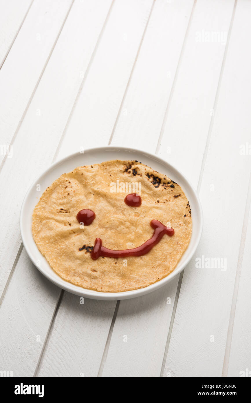 ketchup or fruit jelly/jam smile emoticon over indian bread / chapati ...