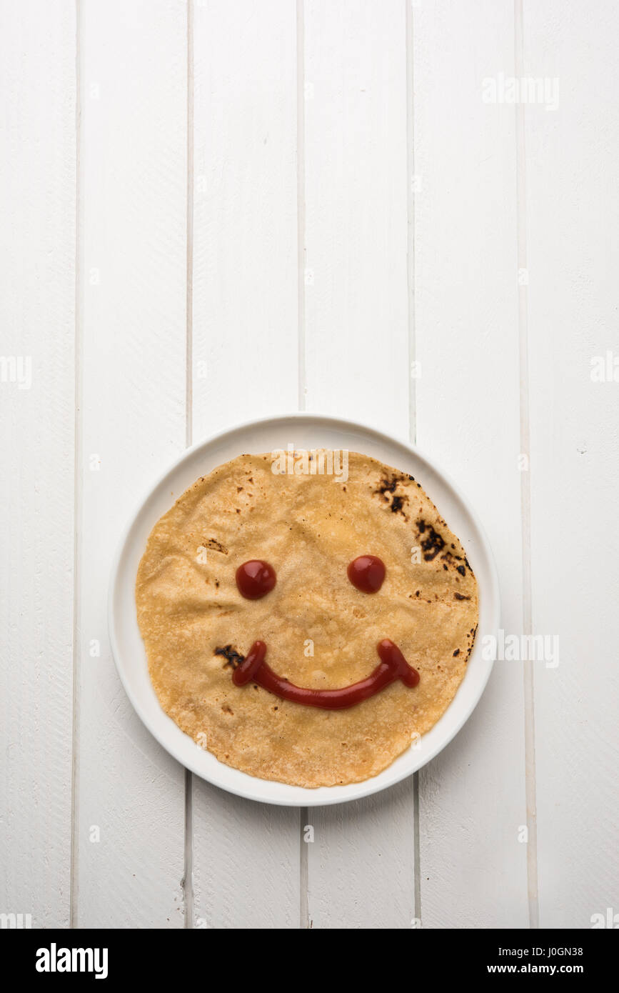 ketchup or fruit jelly/jam smile emoticon over indian bread / chapati ...