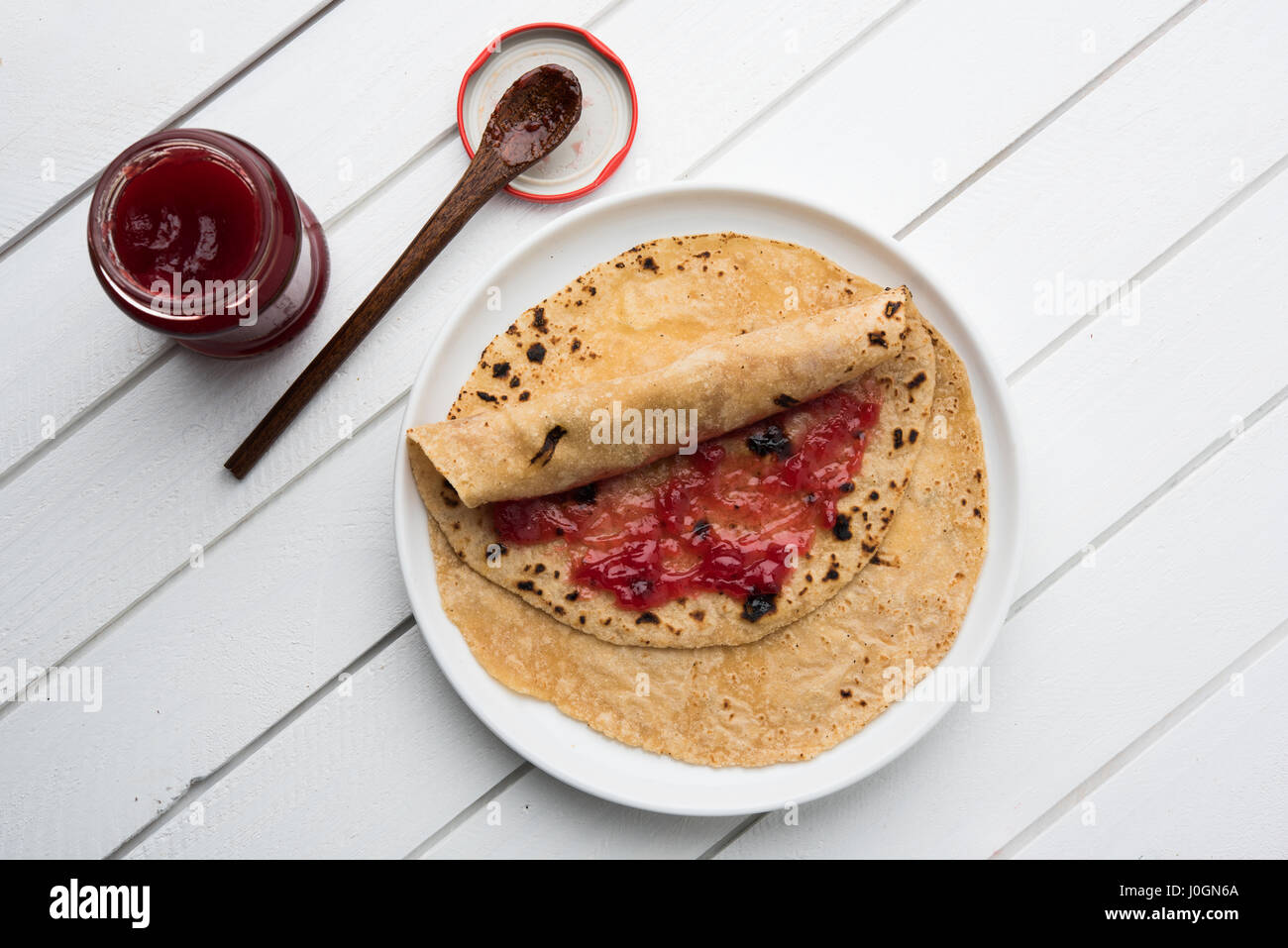indian bread or chapati or paratha rolled with fruit jam, typical ...