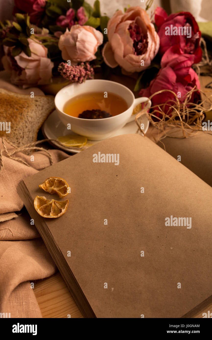 Craft paper note with cup of tea, flowers, peonies, old vintage clock ...