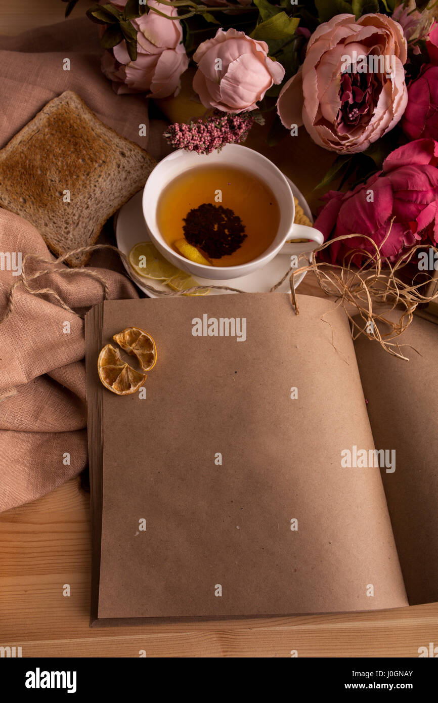 Craft paper note with cup of tea, flowers, peonies, old vintage clock ...