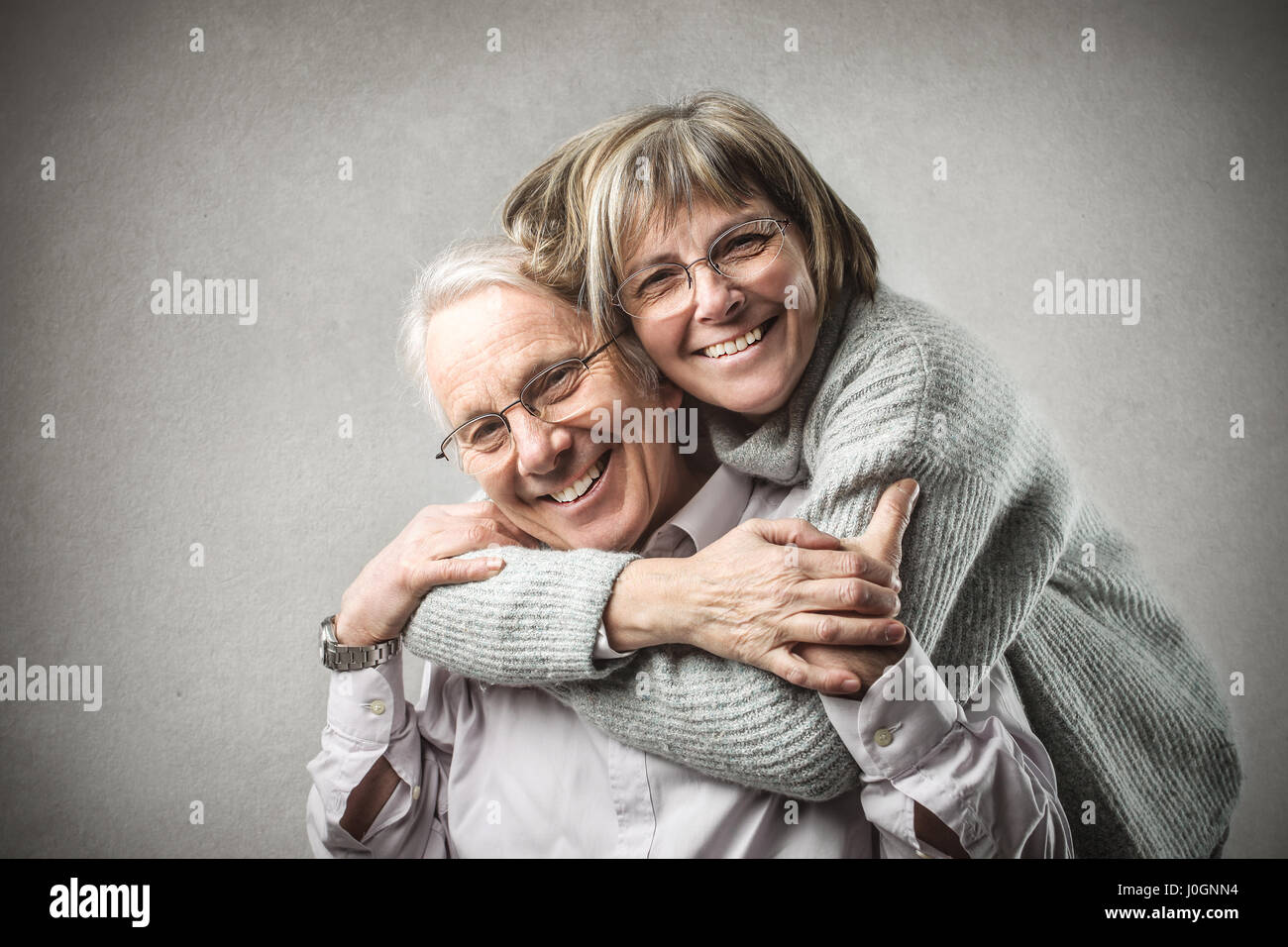 Old couple hugging each other and smiling Stock Photo - Alamy