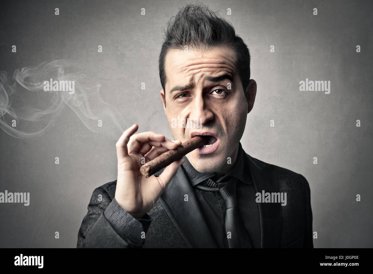 Gangster man smoking cigar Stock Photo - Alamy