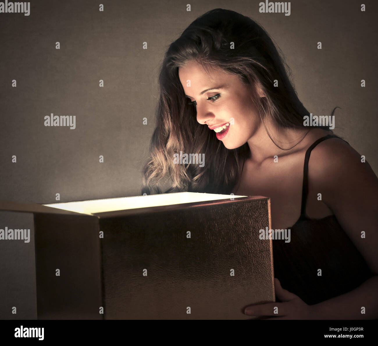 Brunette woman opening box Stock Photo - Alamy
