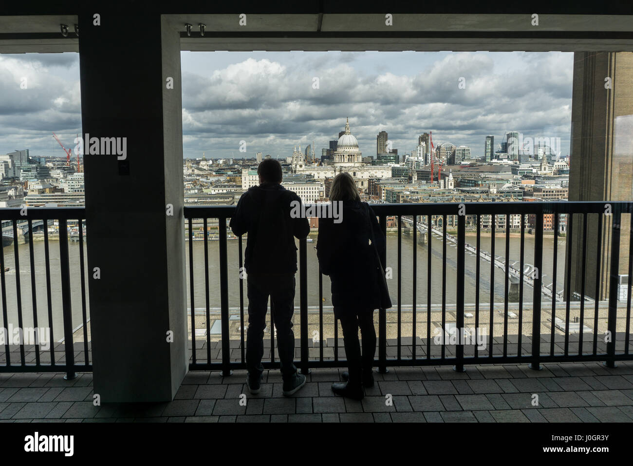 Two people stand by the railing on the Tate Modern veiwing gallery ...