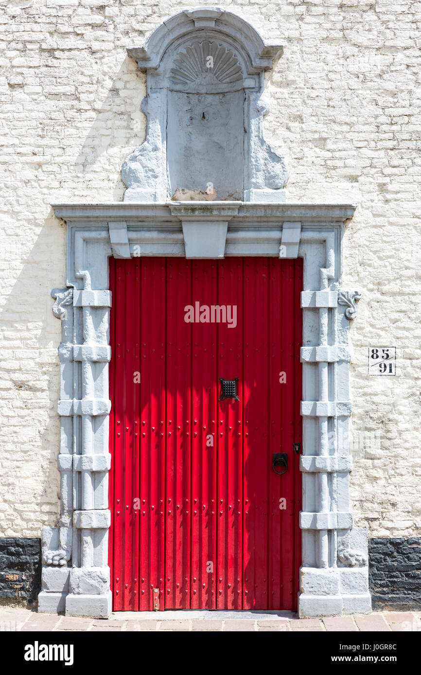Traditional Belgian architecture red door and doorway portico in Bruges ...