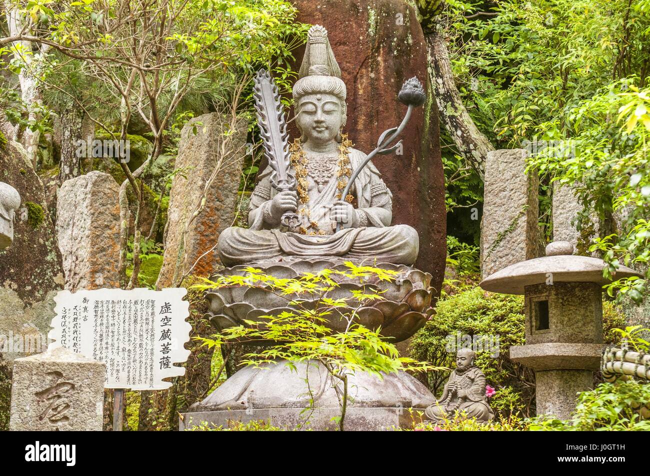 Budda statue stands peacefully at the Daisho in temple of Miyajima ...