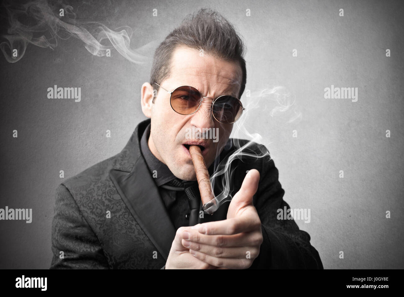 Man in suit smoking cigar Stock Photo - Alamy