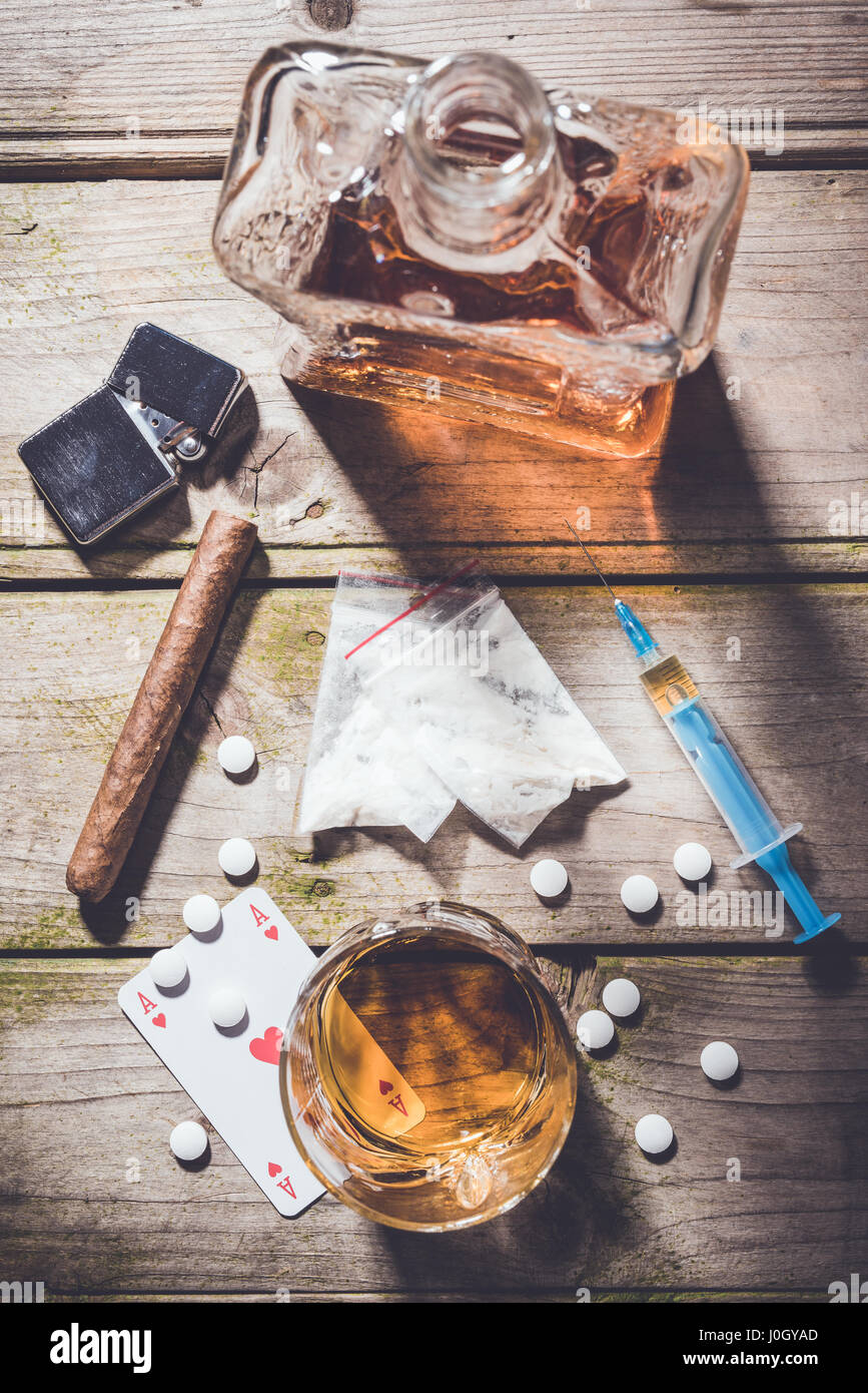 Overhead shot of hard drugs and alcohol on wooden table. Addiction ...