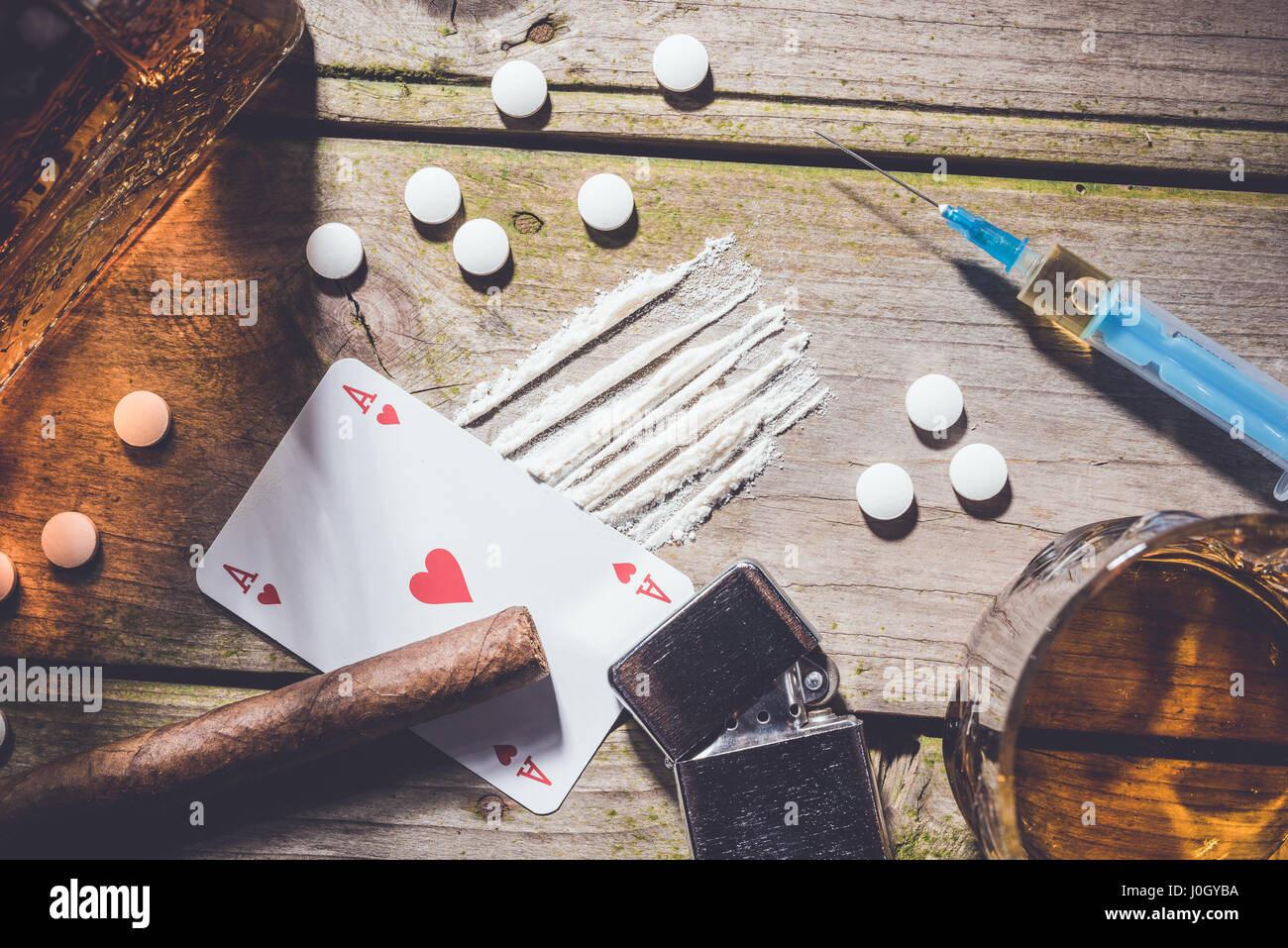 Overhead shot of hard drugs and alcohol on wooden table. Addiction ...