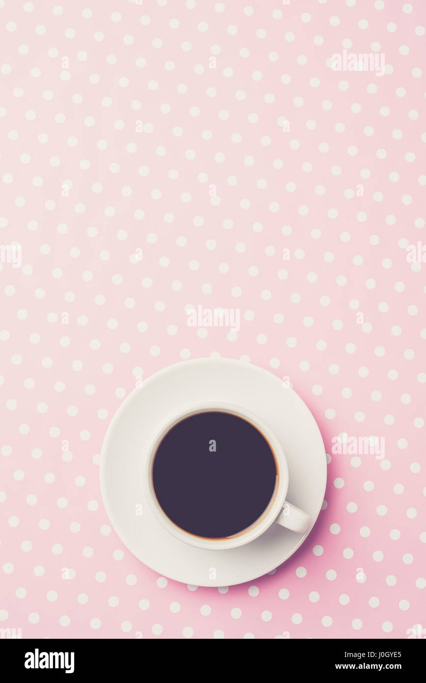 Coffee cup on pink dotted table Stock Photo - Alamy