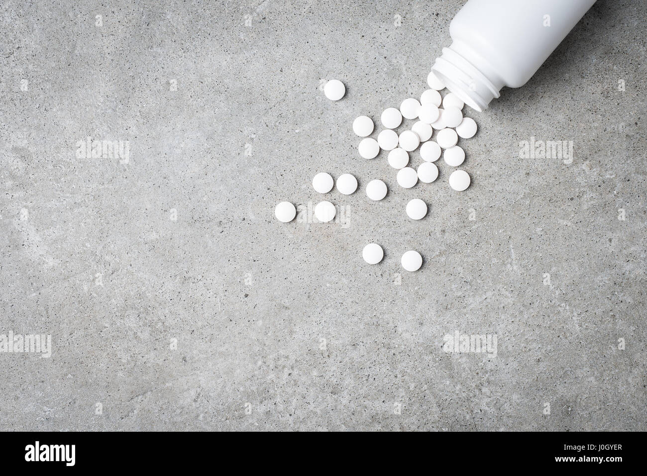 Pill bottle on gray stone background Stock Photo - Alamy