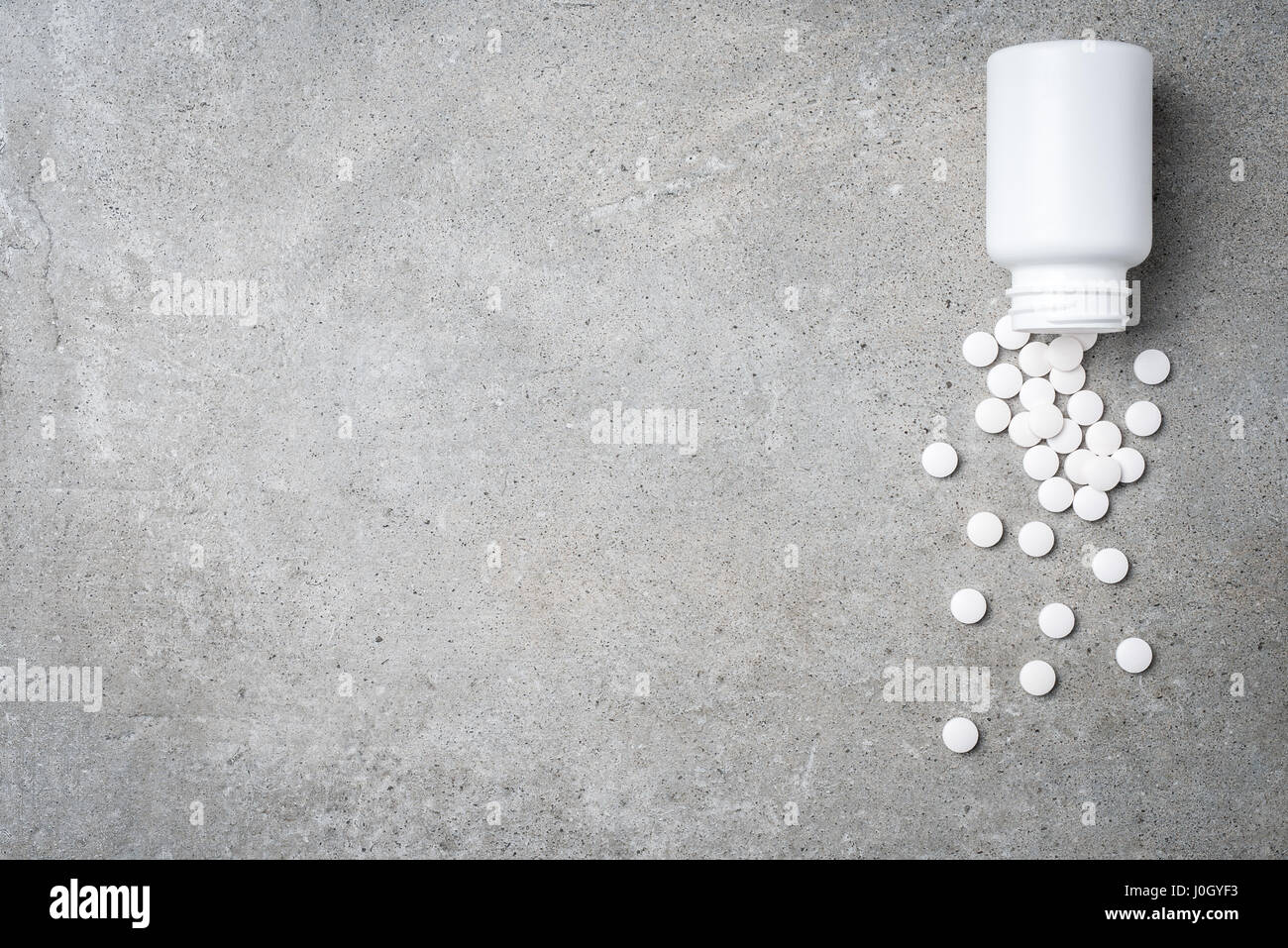 Pill bottle on gray stone background Stock Photo - Alamy