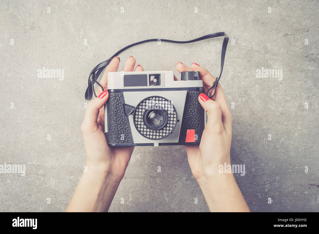 Woman's hands holding retro camera over stone background Stock Photo ...