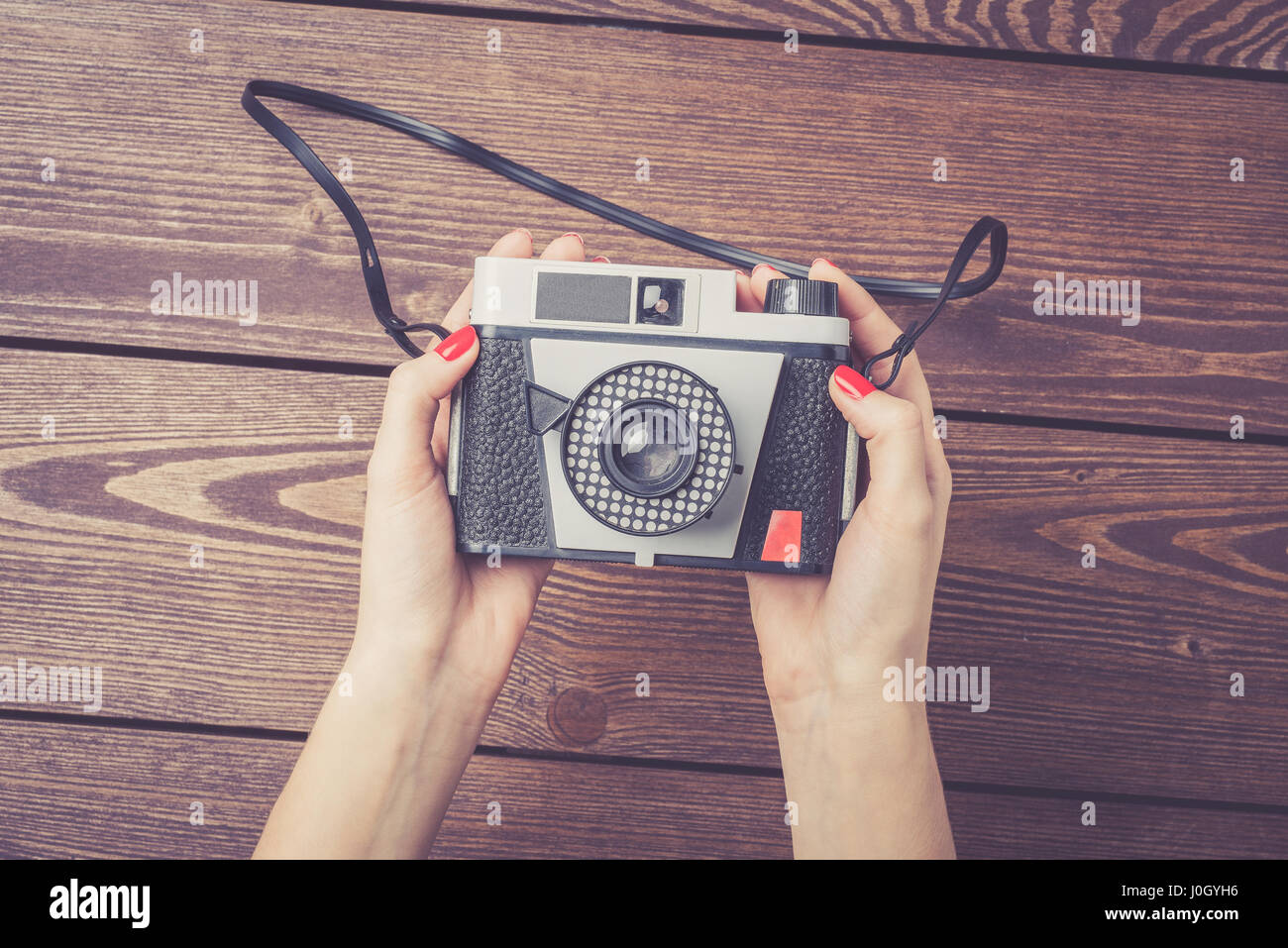 Woman's hands holding retro camera over stone background Stock Photo ...