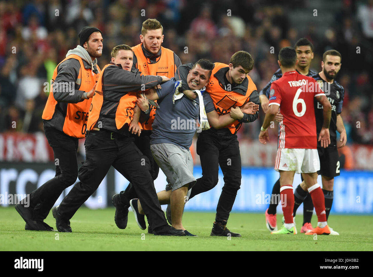 Munich, Germany. 12th Apr, 2017. Security forces carry a streaker off ...
