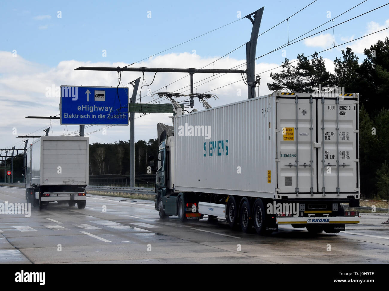 A truck powered by electric overhead lines drives along an 'eHighway ...