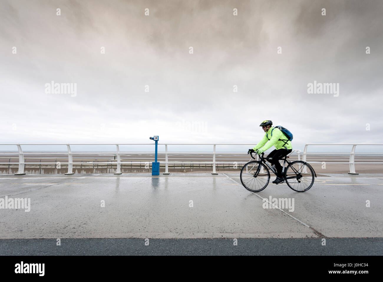 A man cycling alone the wales coastal path and promenade at the popular ...