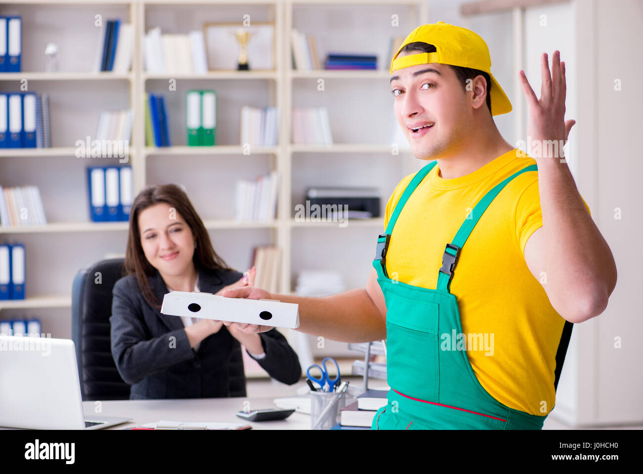 Postman delivering parcel to the office Stock Photo - Alamy