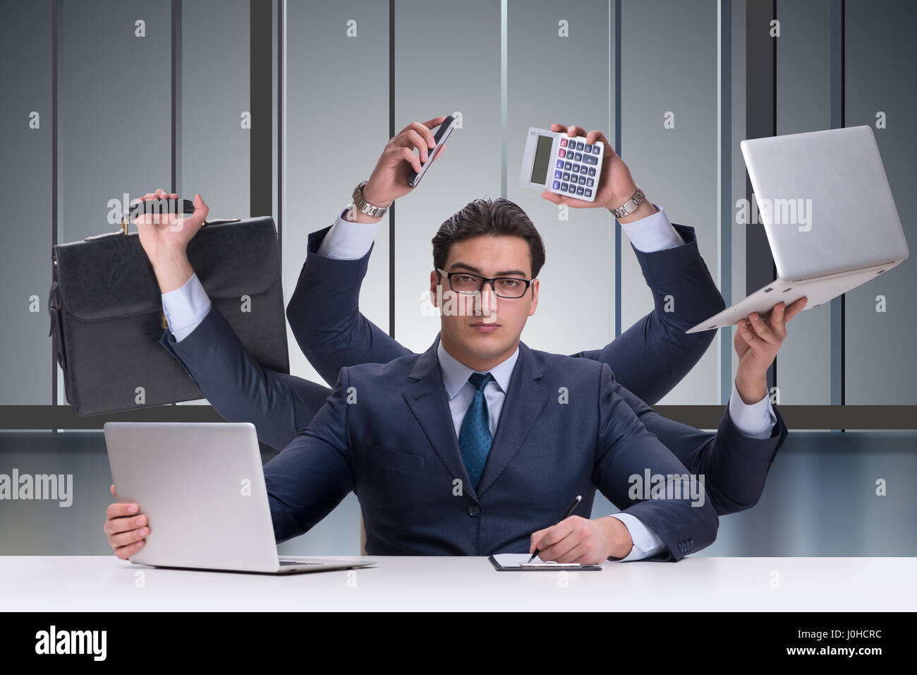 Multitasking employee talking smartphone writing hi-res stock ...