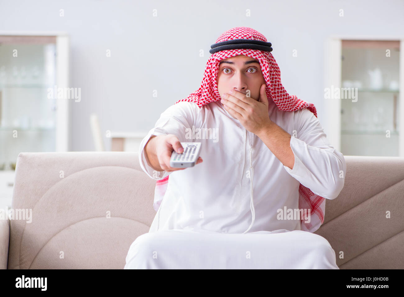 Arab man watching tv at home Stock Photo - Alamy
