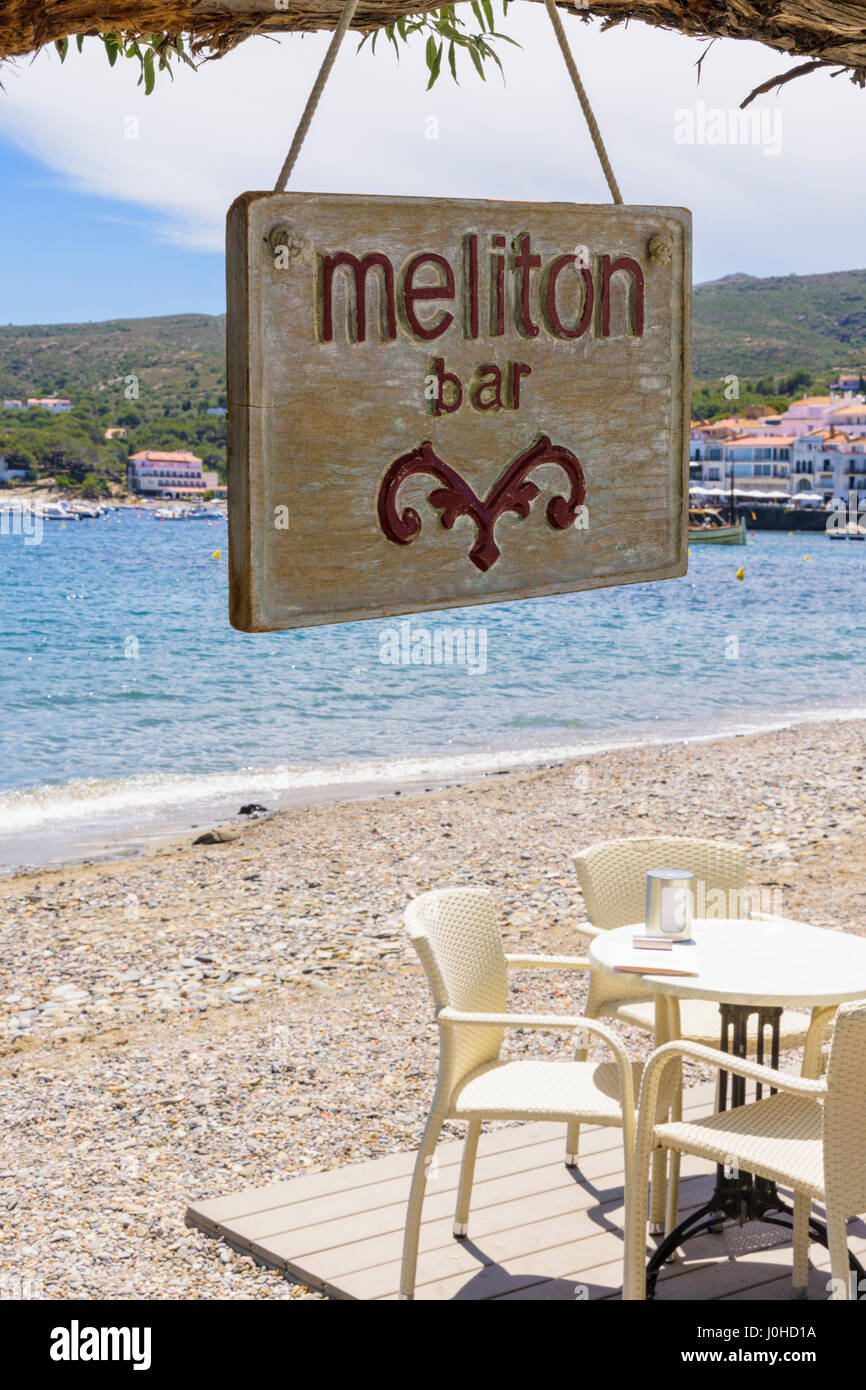 Focus on Meliton Bar sign hanging from a tree branch at a beach side ...