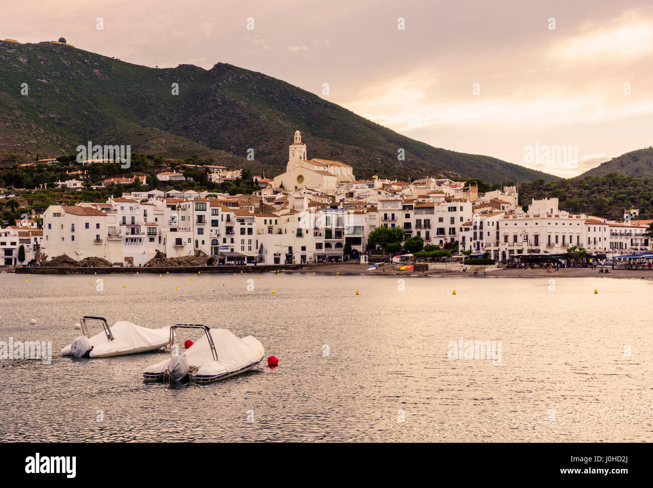 Sunset over the whitewashed village of Cadaques topped by the Church of ...
