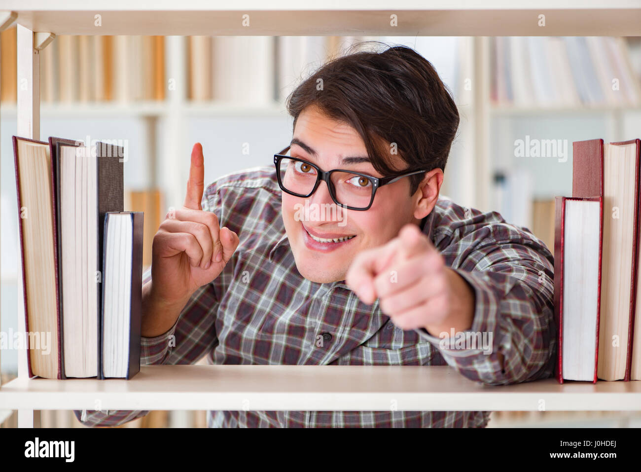 Young student looking for books in college library Stock Photo - Alamy