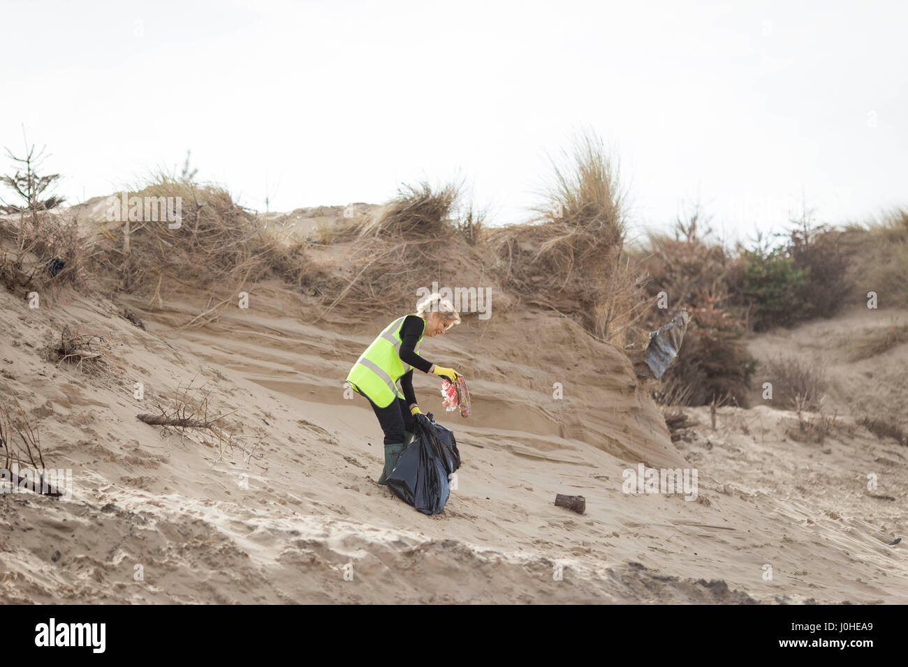 Woman litter picking beach hi-res stock photography and images - Alamy