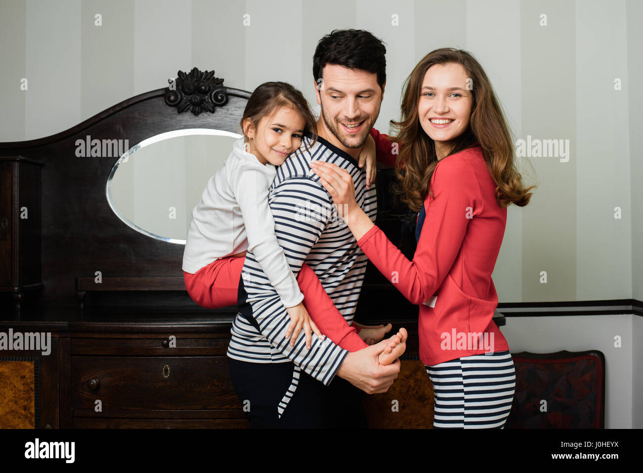 mother, father and daughter standing happy together inside a room Stock ...
