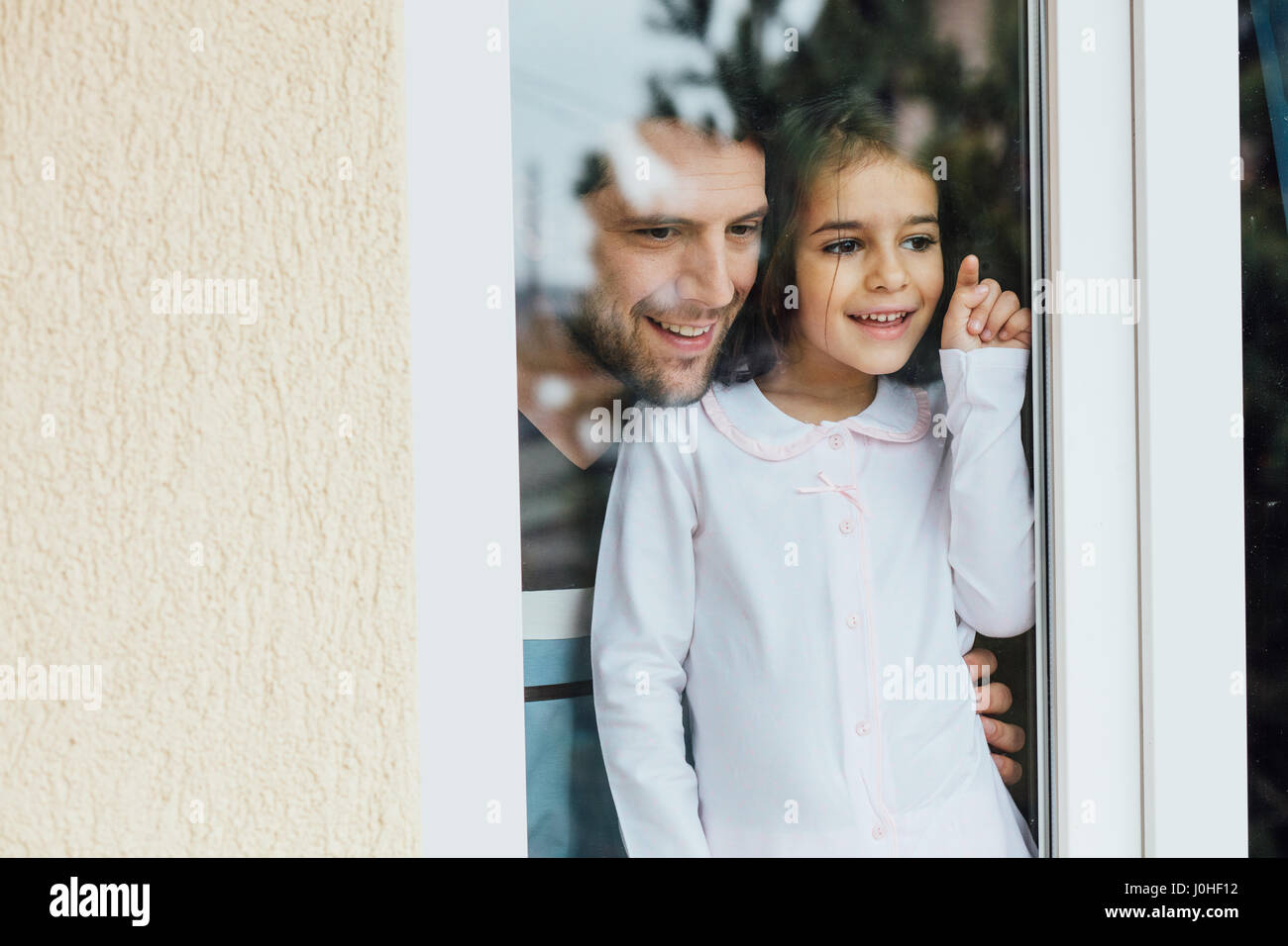 father and daughter looking out the window and smiling Stock Photo - Alamy