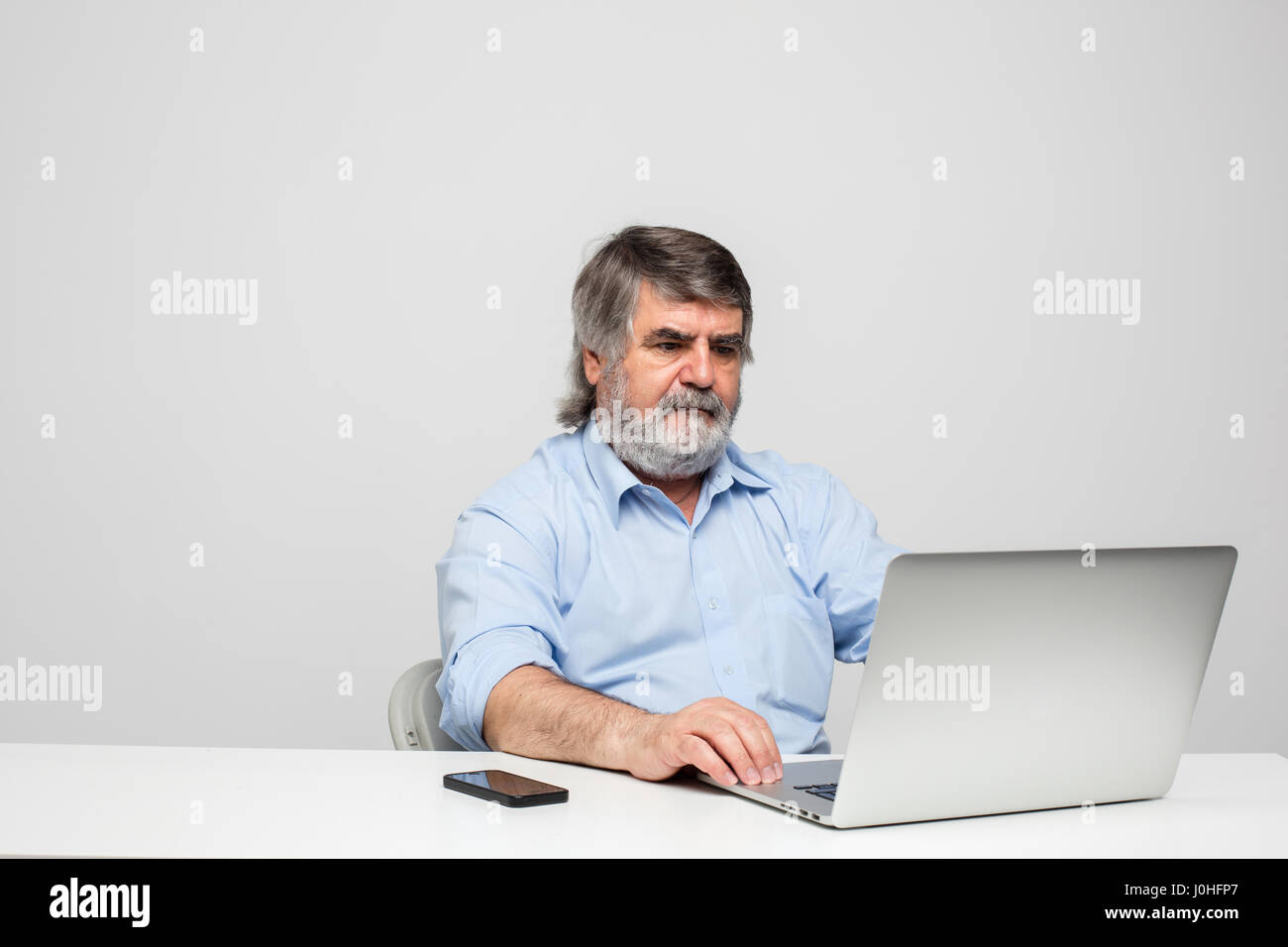 old men in blue shirt having problems in using a laptop Stock Photo - Alamy