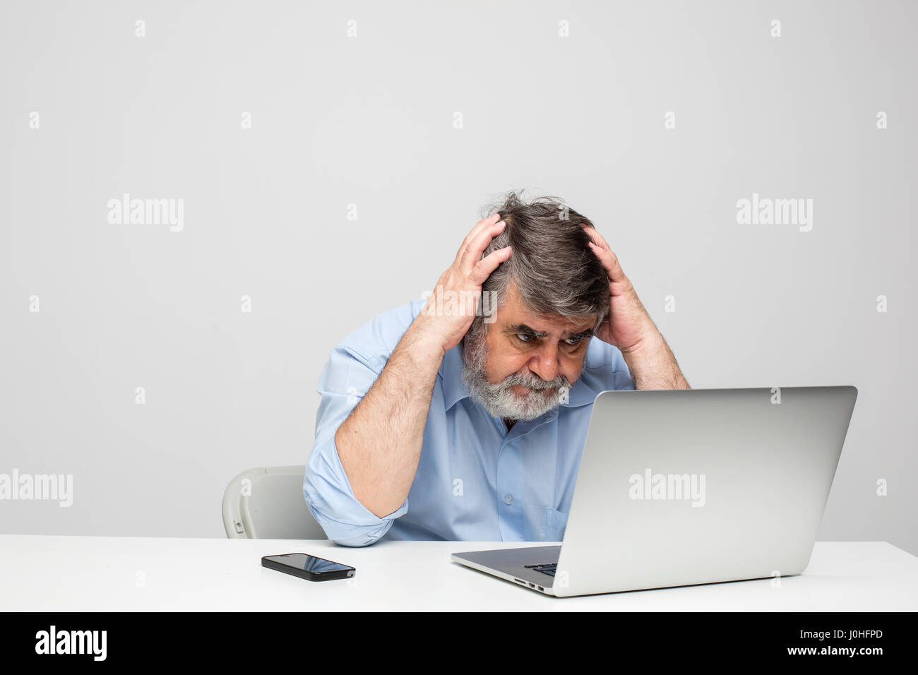 old men in blue shirt having problems in using a laptop Stock Photo - Alamy