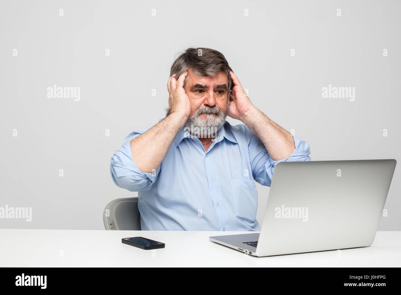 old men in blue shirt having problems in using a laptop Stock Photo - Alamy